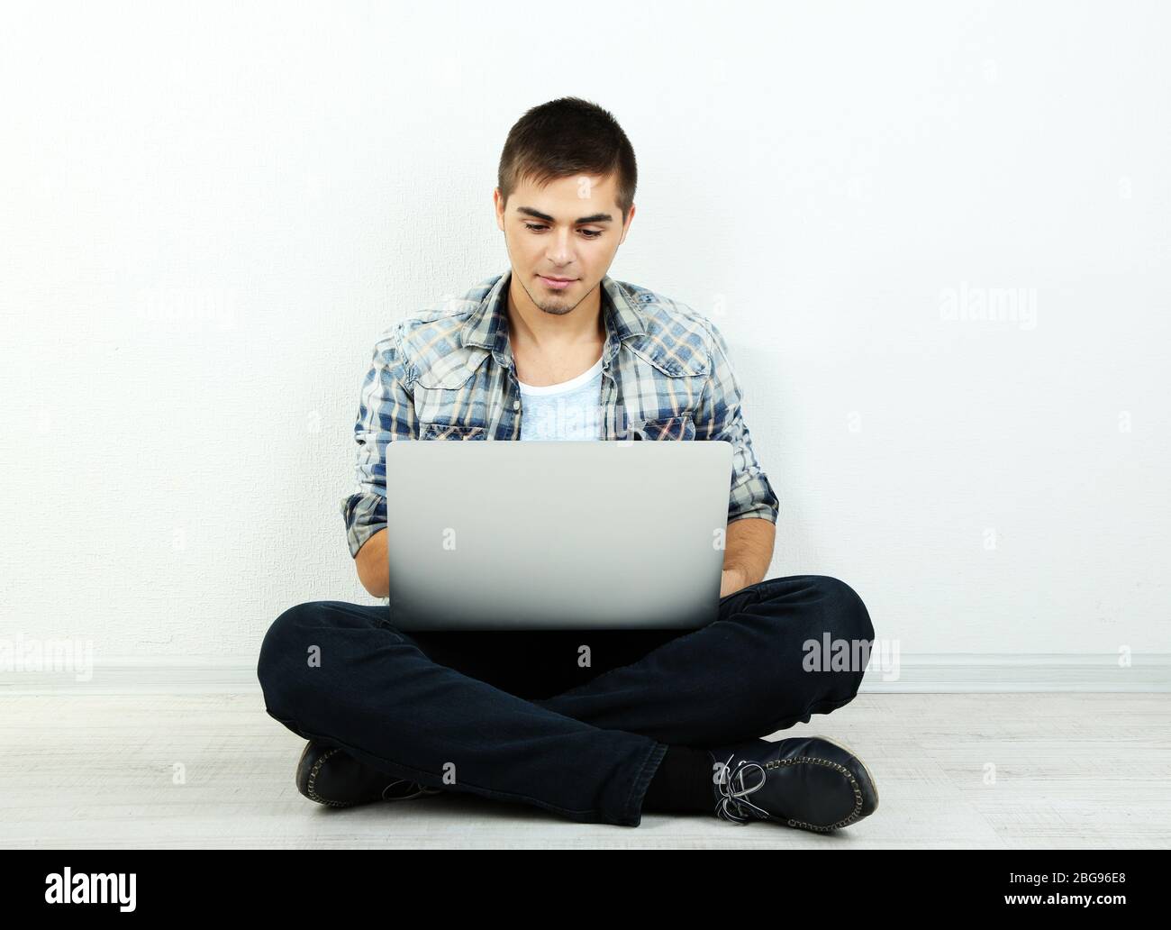 Guy sitting on floor in room Stock Photo - Alamy