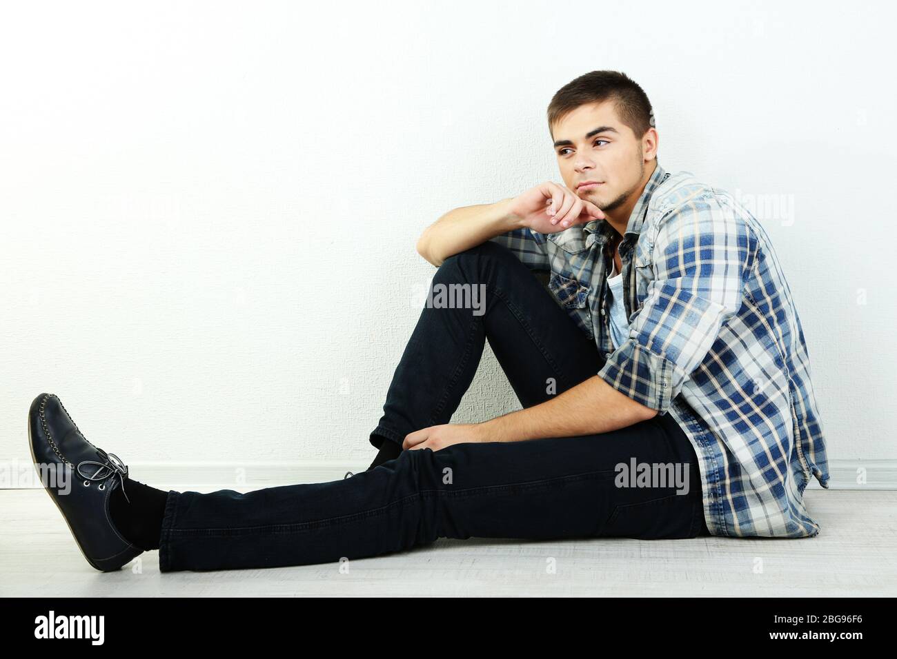 Guy sitting on floor in room Stock Photo - Alamy