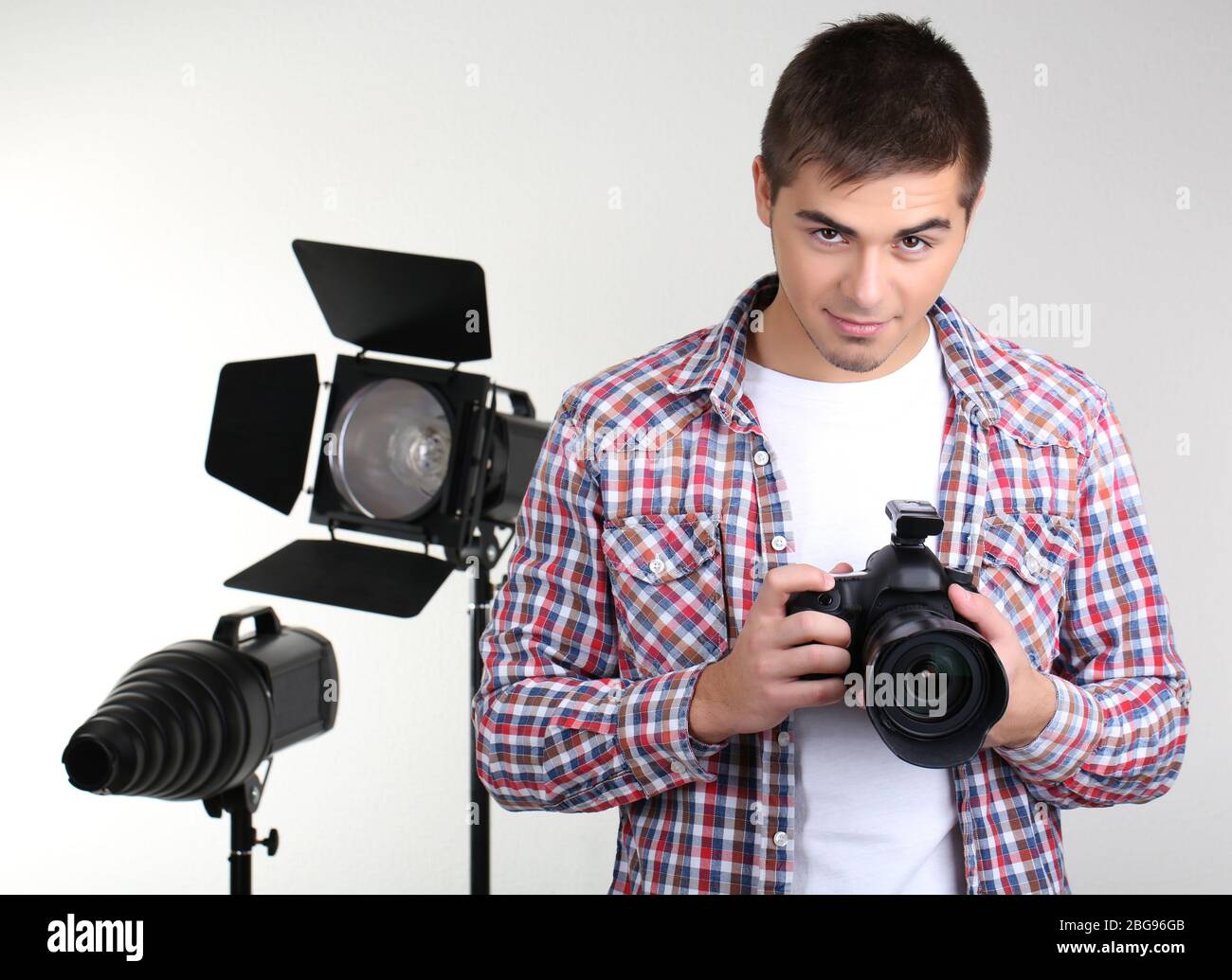 Handsome photographer with camera, on photo studio background Stock ...