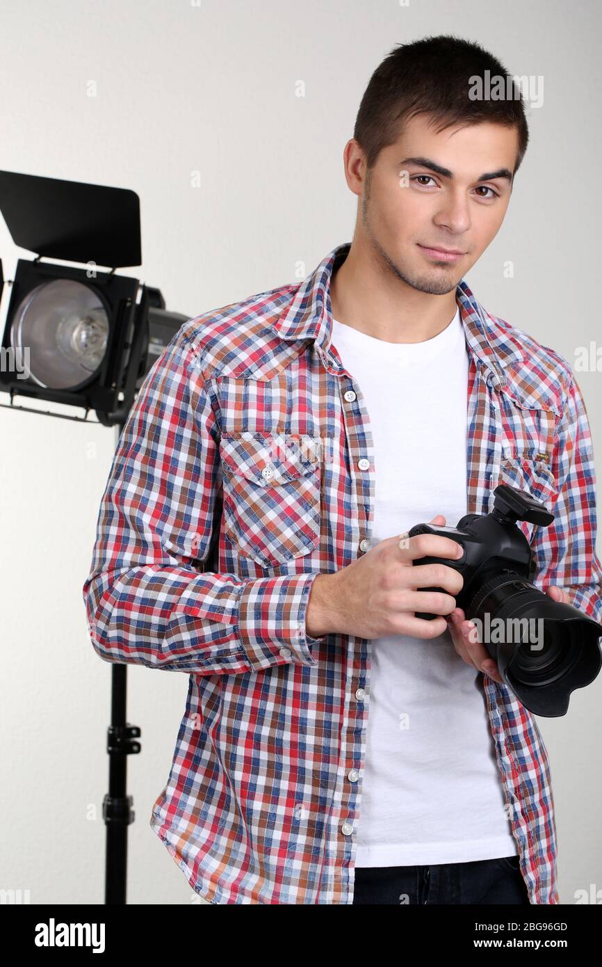 Handsome photographer with camera, on photo studio background Stock ...