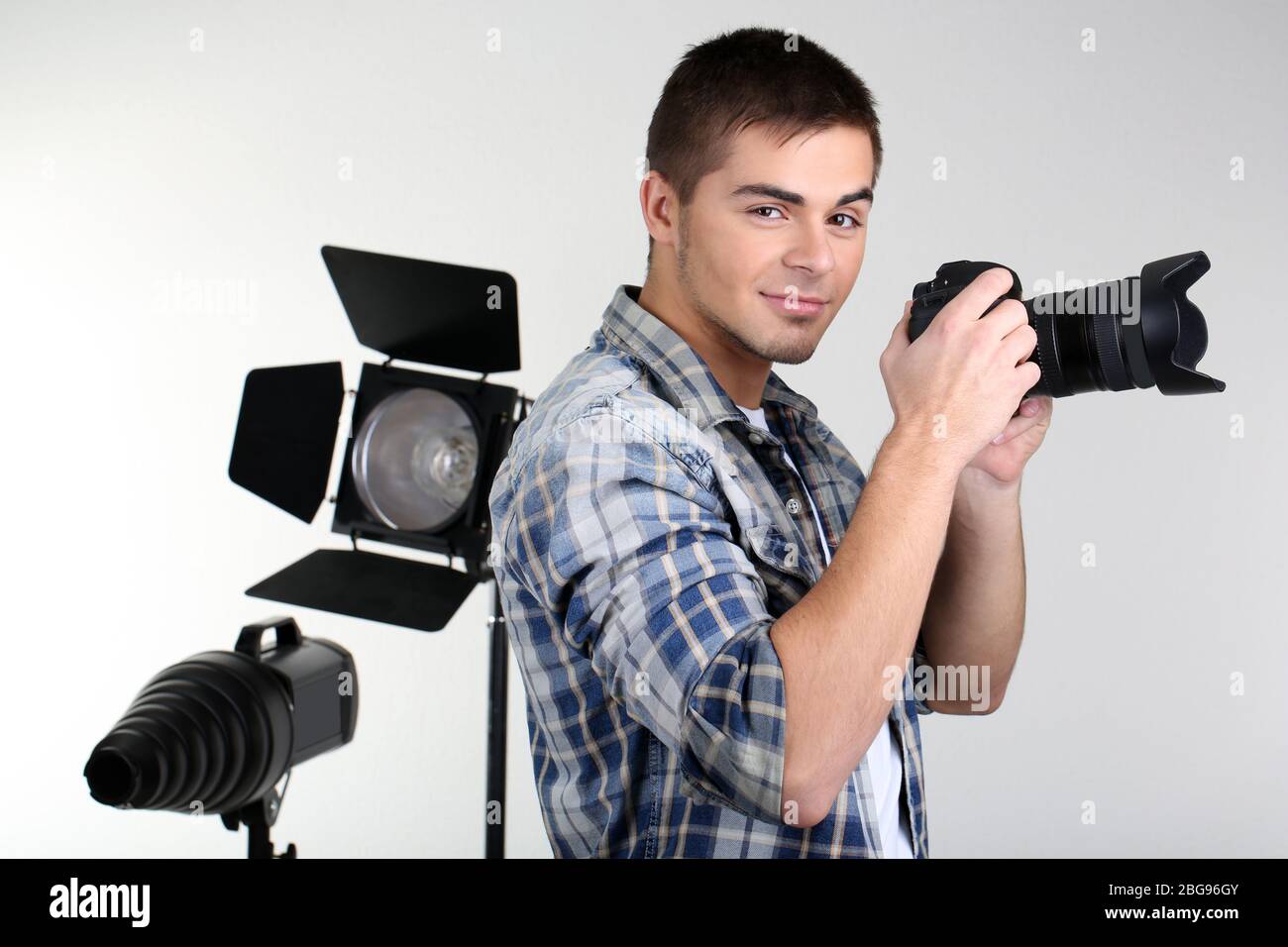 Handsome photographer with camera, on photo studio background Stock ...