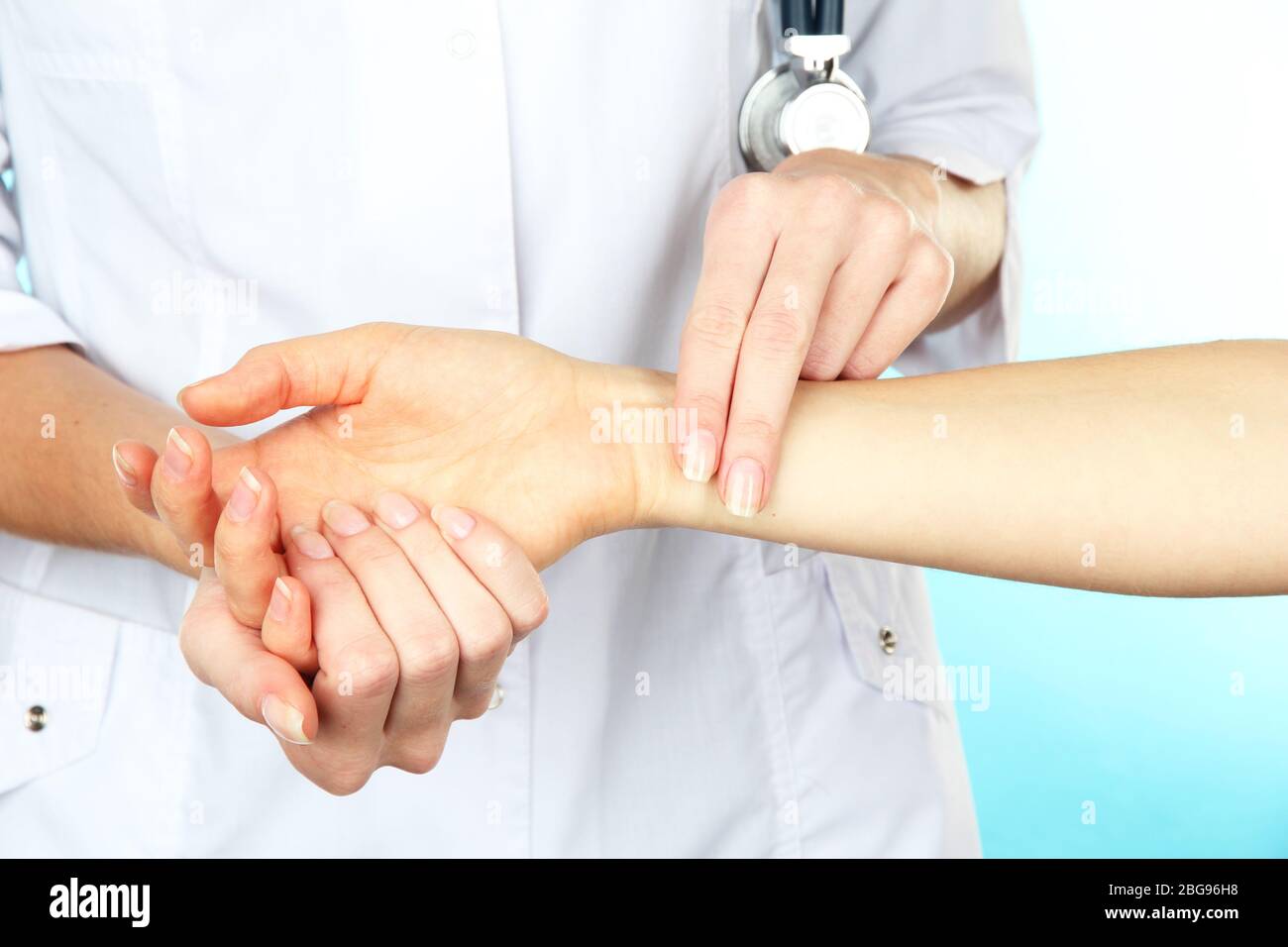 Measuring pulse on light blue background Stock Photo - Alamy