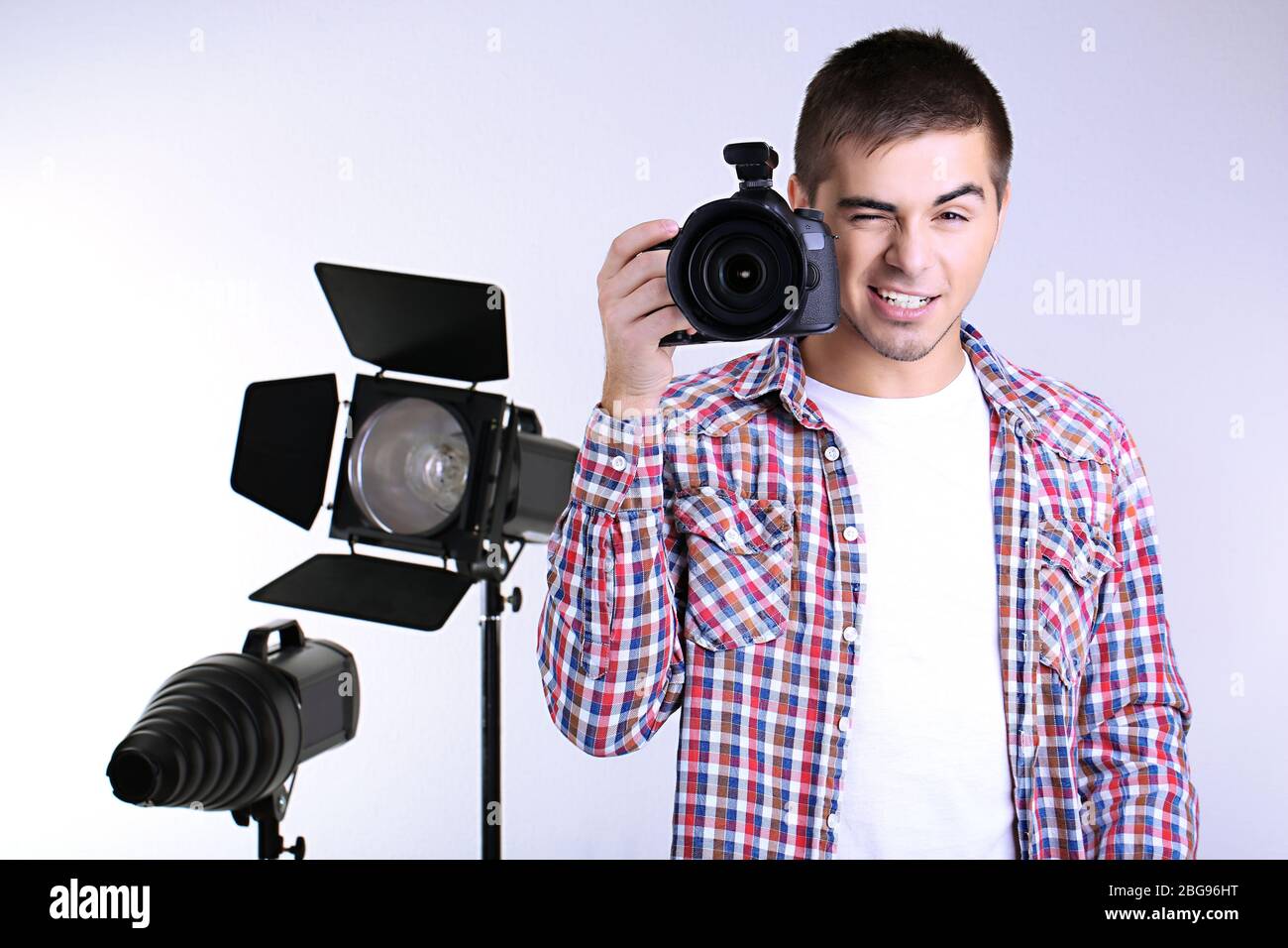Handsome photographer with camera, on photo studio background Stock ...