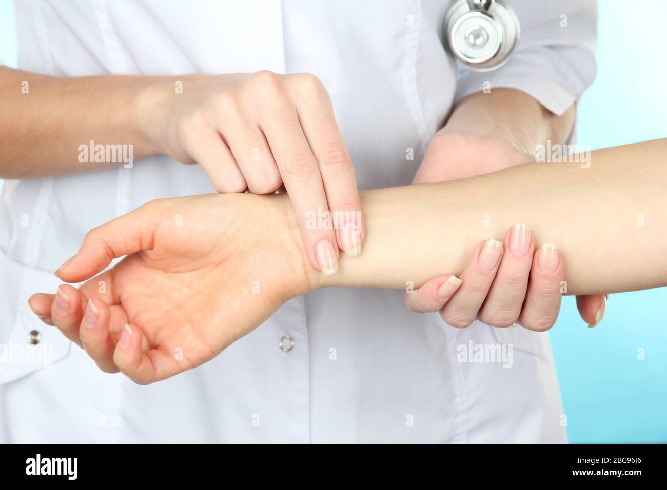 Measuring pulse on light blue background Stock Photo - Alamy