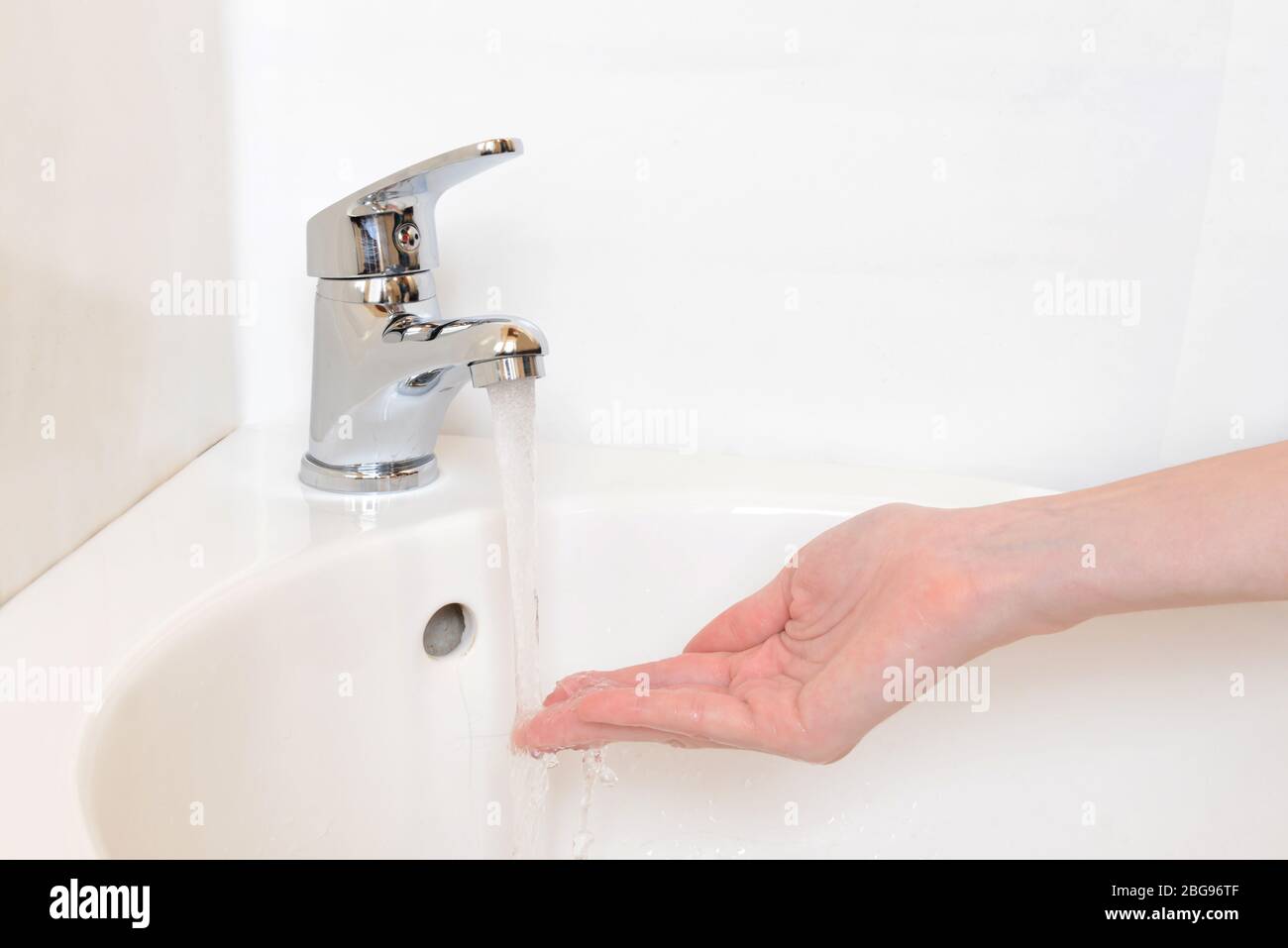 Close-up of human hands being washed under faucet in bathroom, isolated ...