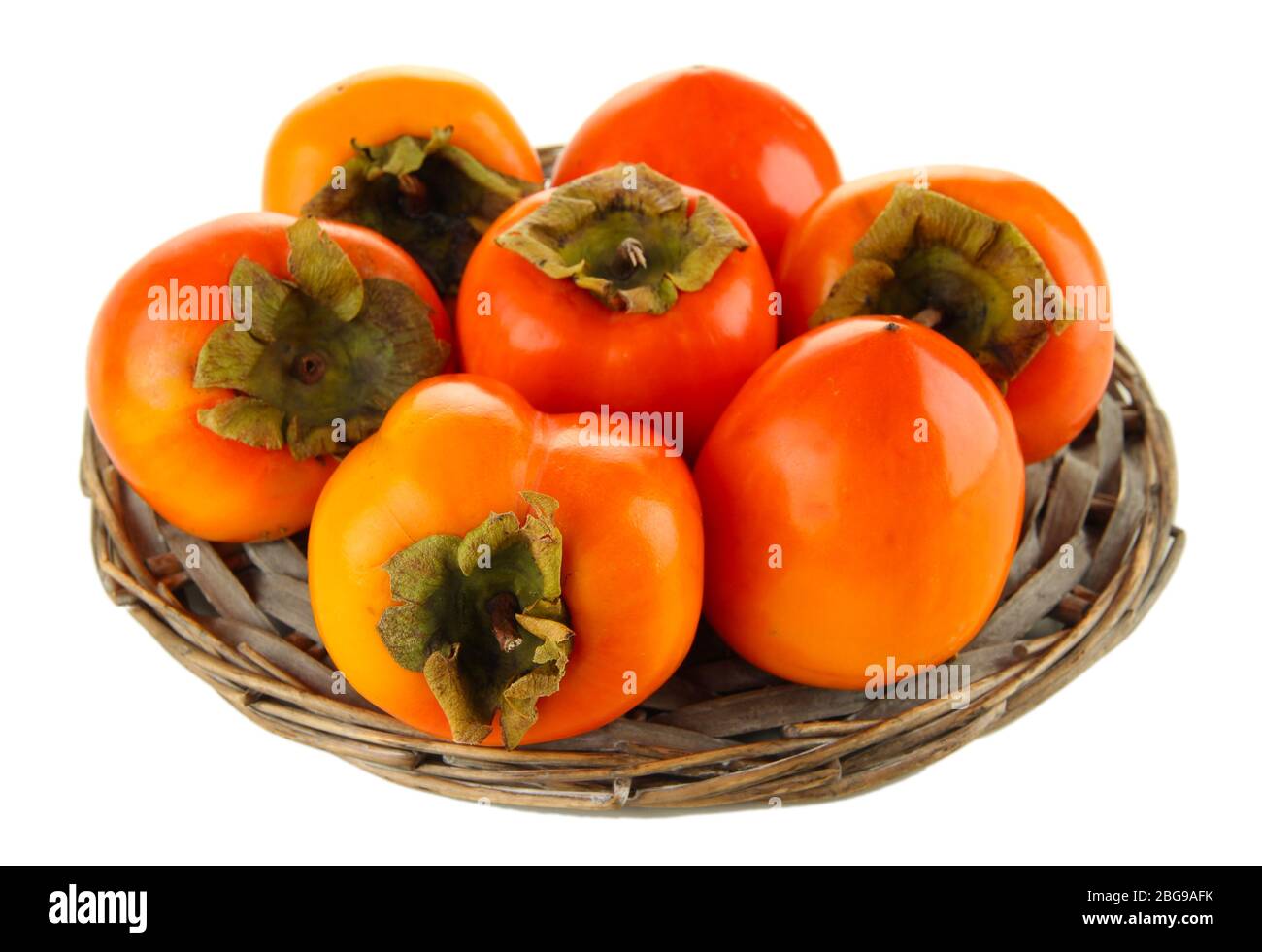 Ripe persimmons on wicker stand isolated on white Stock Photo - Alamy