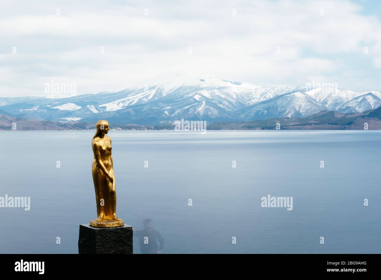 A golden statue of Tatsuko stands against the majestic water of Lake ...
