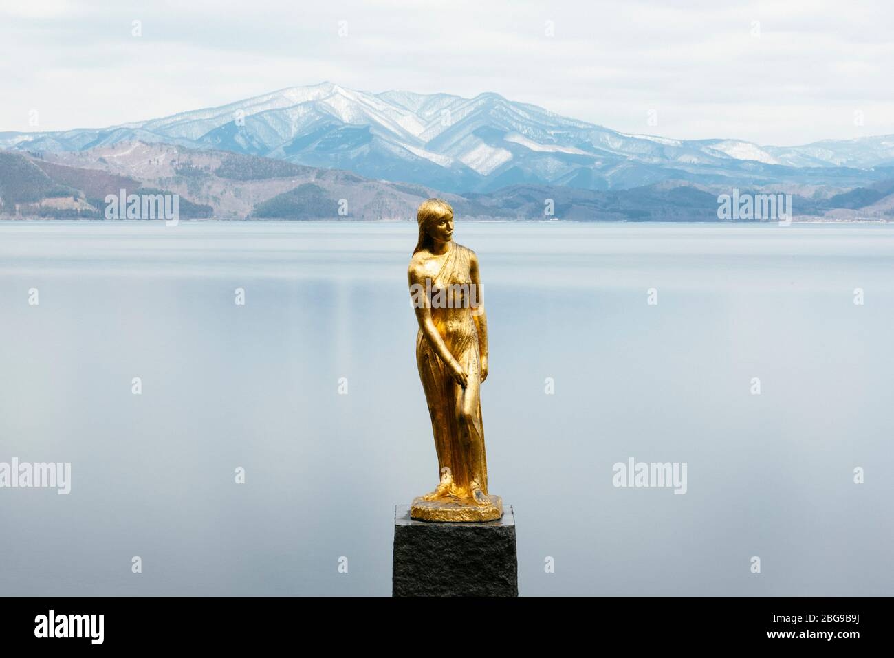 A golden statue of Tatsuko stands against the majestic water of Lake ...