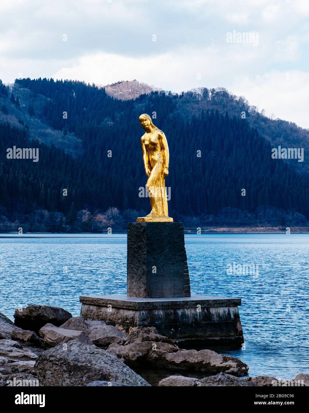 A golden statue of Tatsuko stands against the majestic water of Lake ...