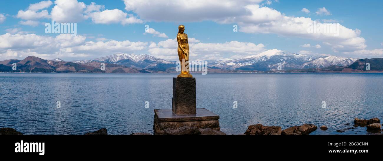 A golden statue of Tatsuko stands against the majestic water of Lake ...