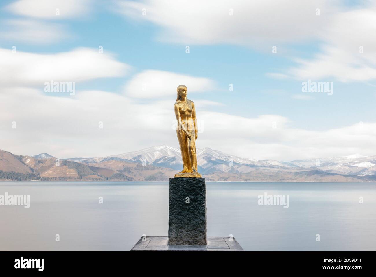 A golden statue of Tatsuko stands against the majestic water of Lake ...