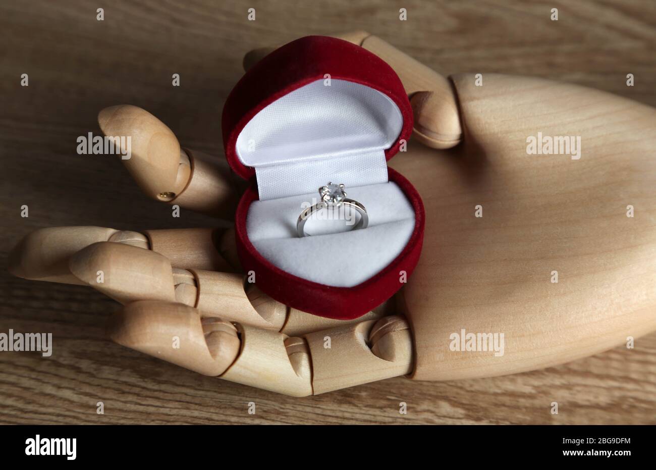 Box with ring in wooden hand isolated on white Stock Photo - Alamy