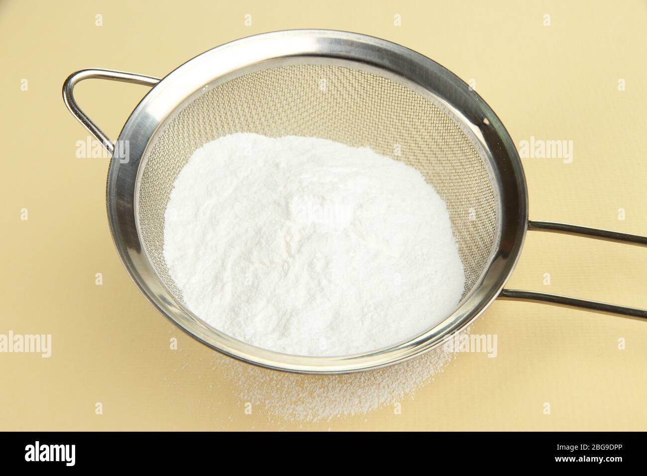 Powdered sugar in metal sieve on beige background Stock Photo - Alamy