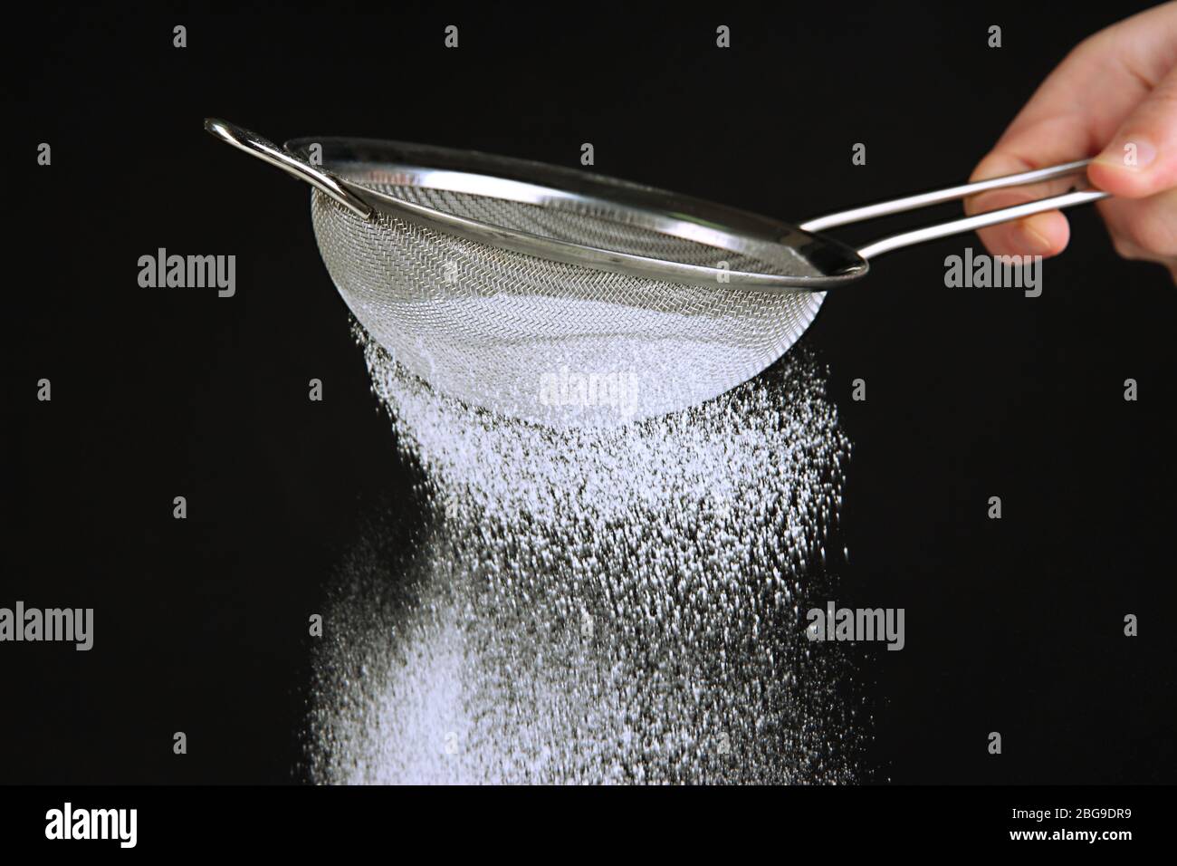 Sieve and powdered sugar on black background Stock Photo - Alamy