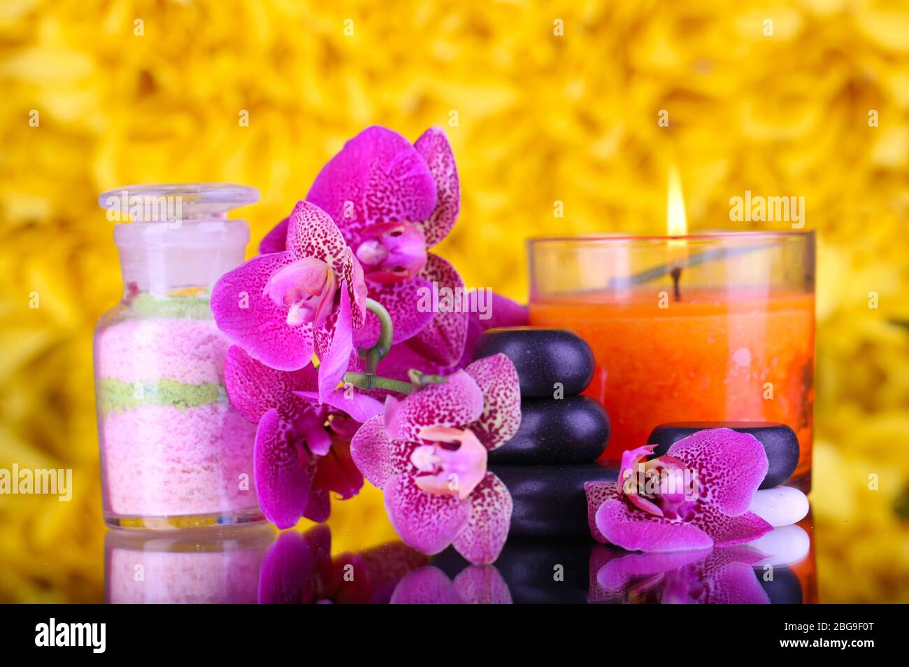 Beautiful spa setting with orchid on yellow background Stock Photo - Alamy