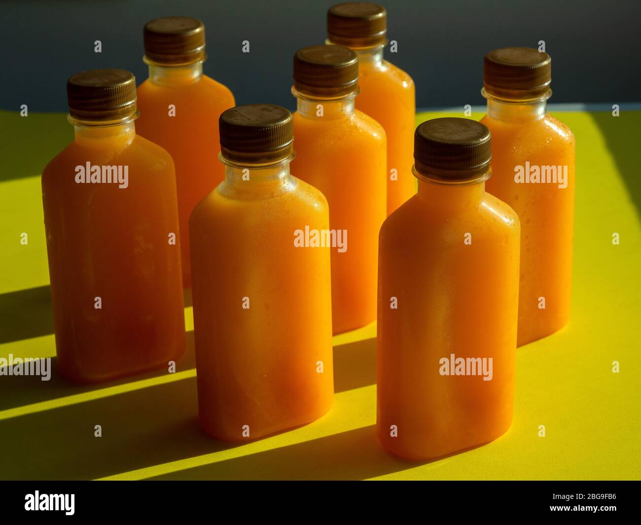 Orange juice iced cold in the bottles. Close-up square shape bottle ...