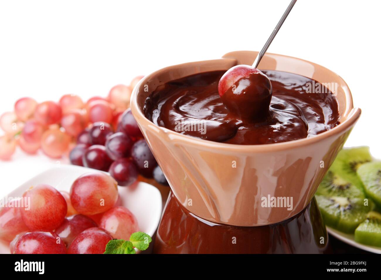 Chocolate fondue with sliced fruits, isolated on white Stock Photo - Alamy