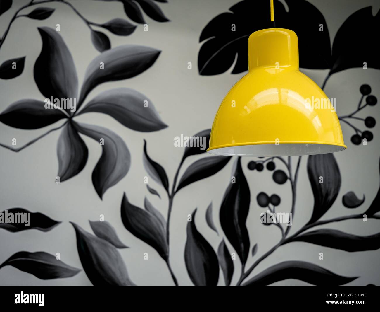 Modern yellow ceiling light on wallpaper, tropical palm leaves in black ...