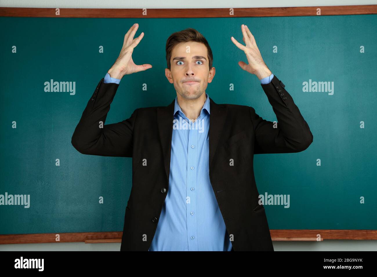 Young teacher near chalkboard in school classroom Stock Photo - Alamy