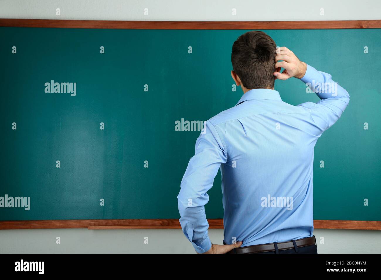 Young teacher near chalkboard in school classroom Stock Photo - Alamy