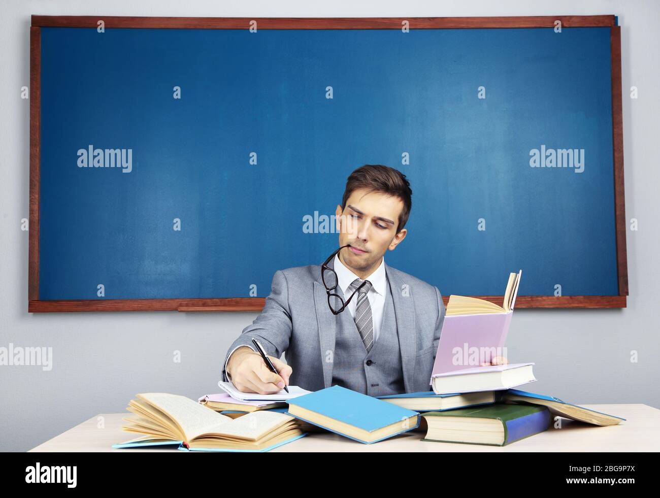 Young teacher sitting in school classroom Stock Photo - Alamy