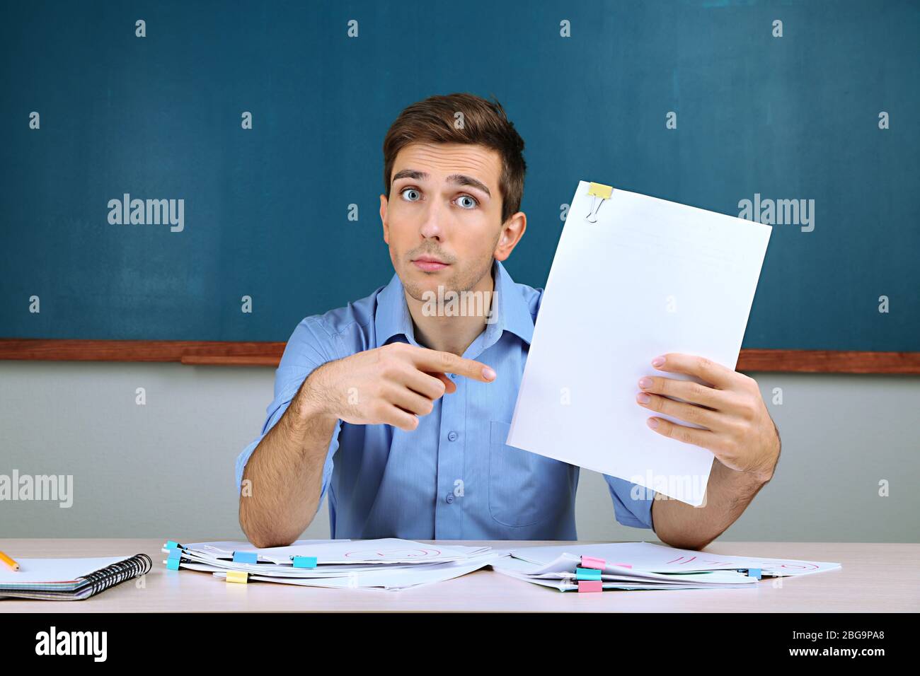 Young teacher review tests in school classroom Stock Photo - Alamy