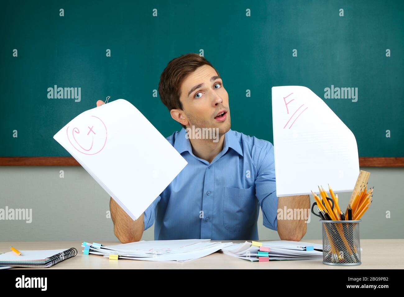 Young teacher review tests in school classroom Stock Photo - Alamy