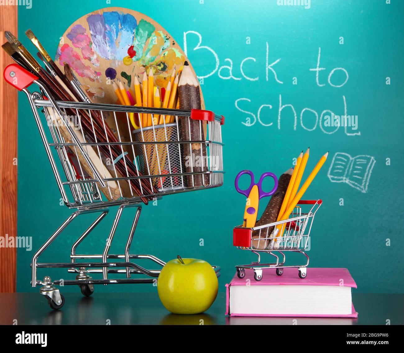 School supplies in supermarket carts on blackboard background Stock ...