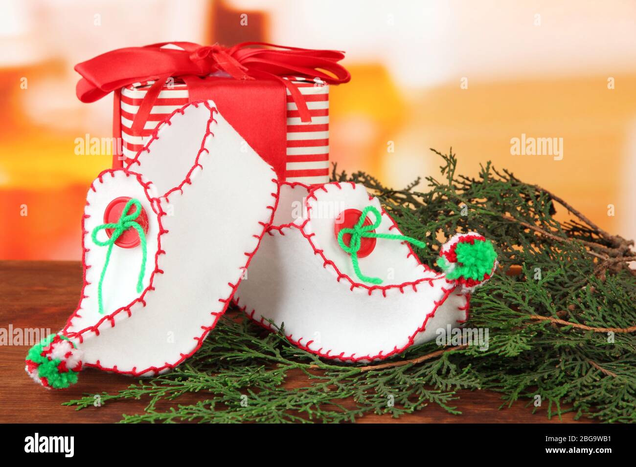 Decorative Christmas shoes with present on table on bright background ...