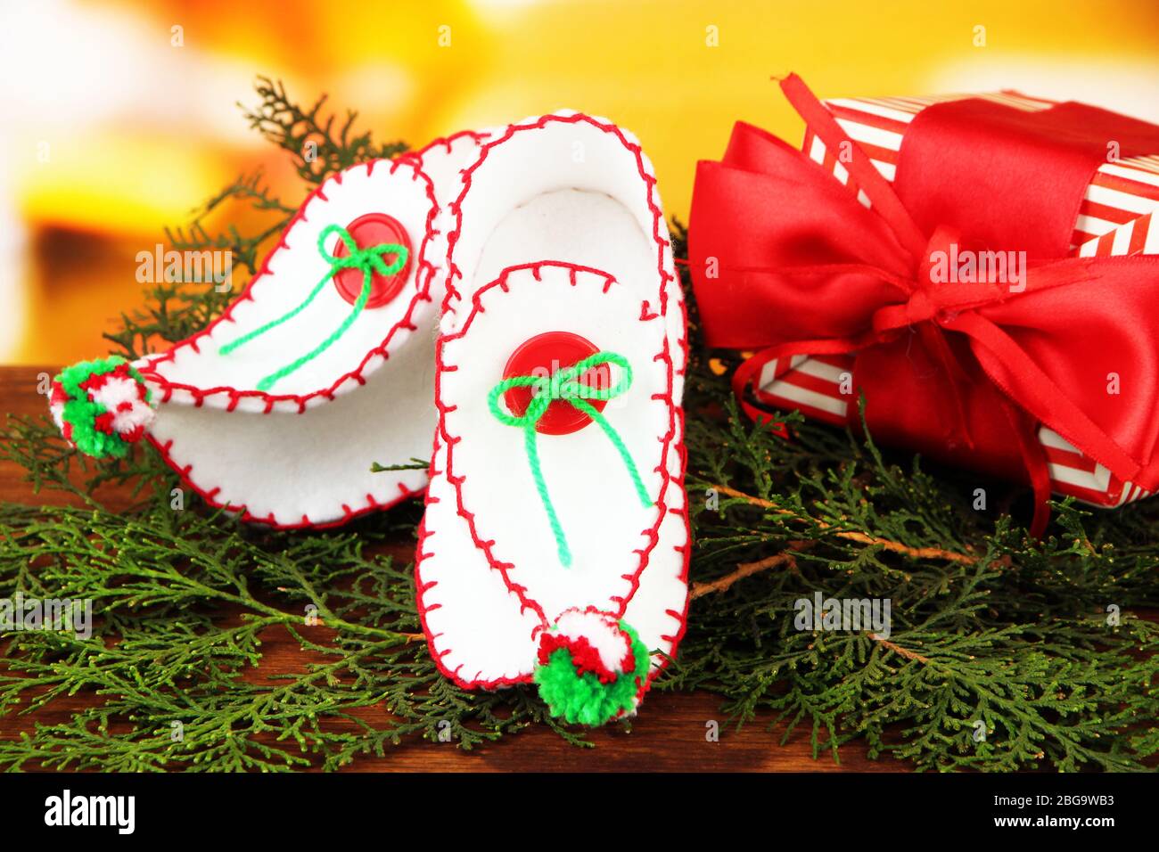 Decorative Christmas shoes with present on table on bright background ...