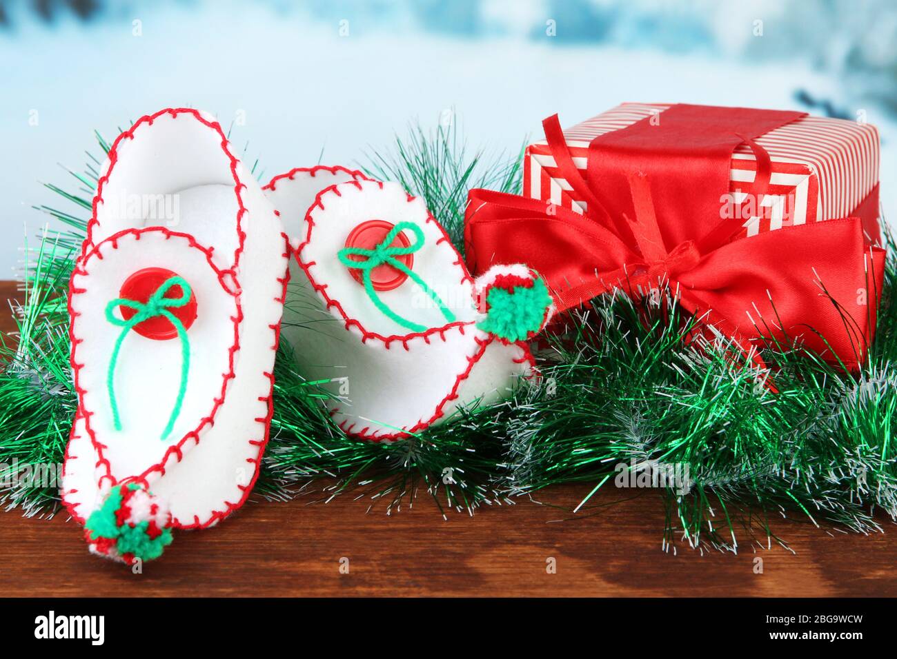 Decorative Christmas shoes with present on table on bright background ...