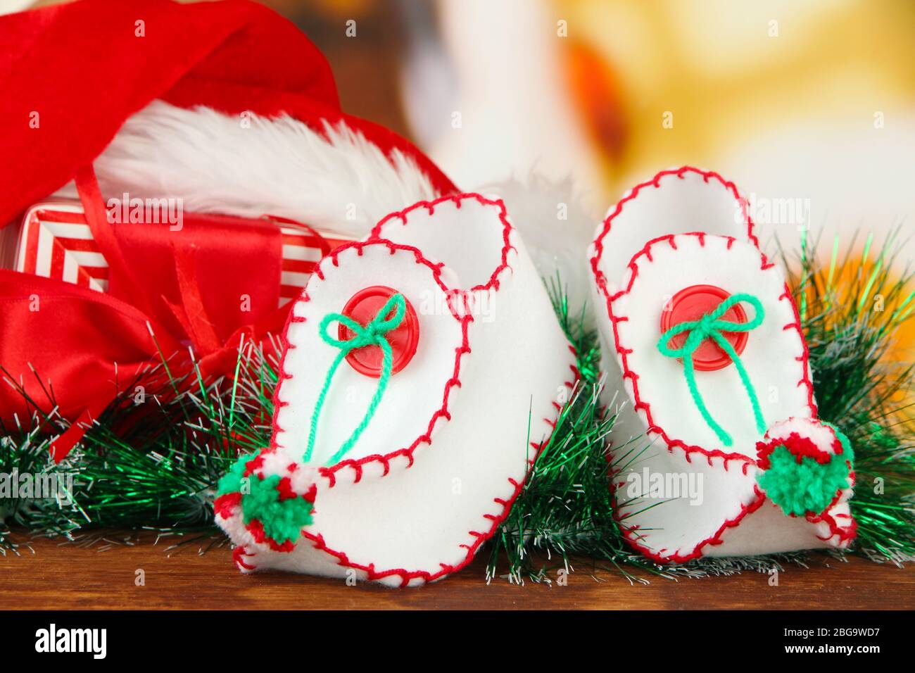 Decorative Christmas shoes with present on table on bright background ...