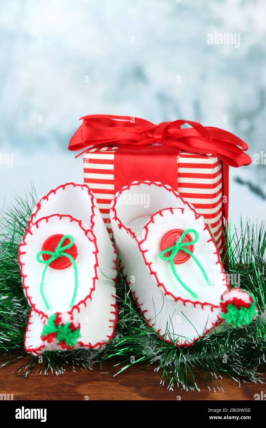 Decorative Christmas shoes with present on table on bright background ...