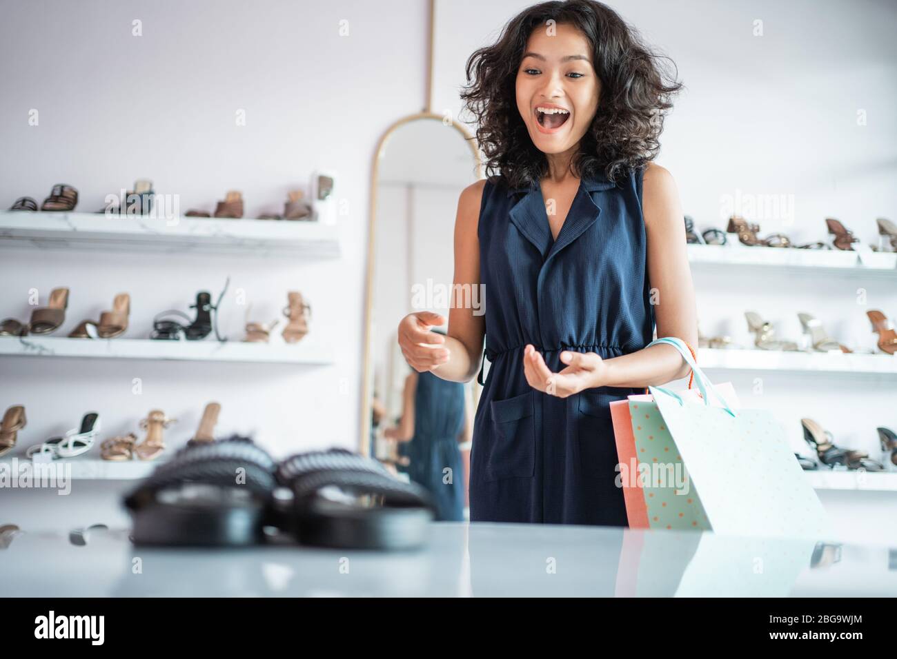 excited surprised asian woman shopping looking at shoes in the shop ...