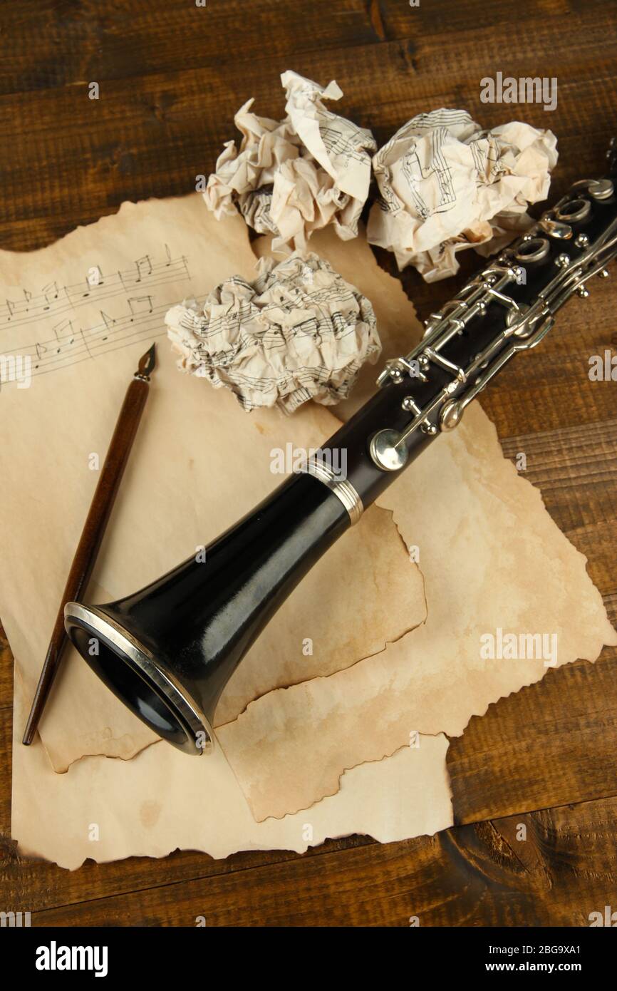 Crumpled paper balls with music sheets and clarinet on wooden ...