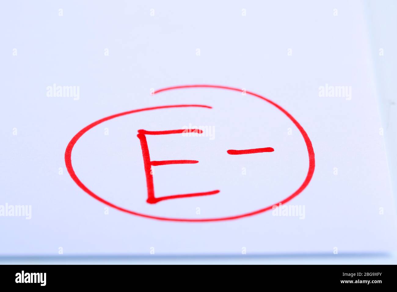 Grade E- written on an exam paper Stock Photo - Alamy