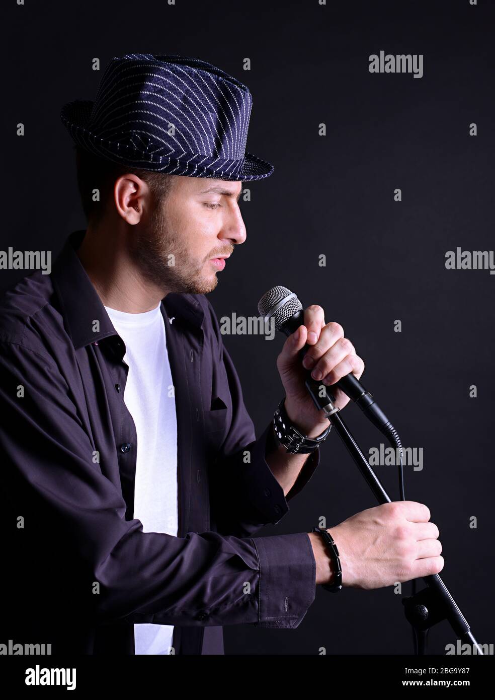 Young musician singing, on gray background Stock Photo - Alamy