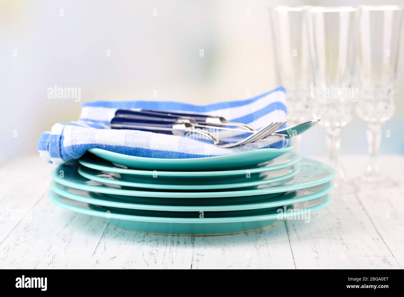 Clean dishes on wooden table on light background Stock Photo - Alamy