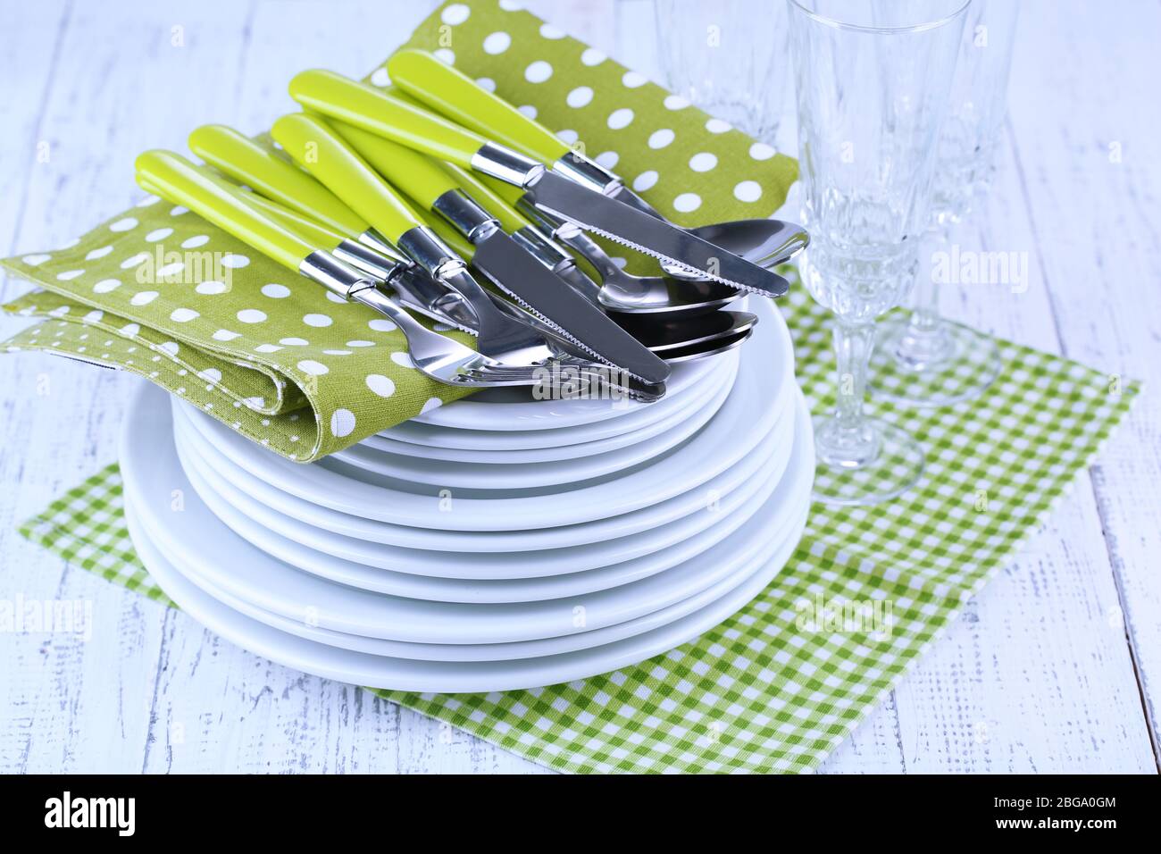 Clean dishes on wooden table on light background Stock Photo - Alamy