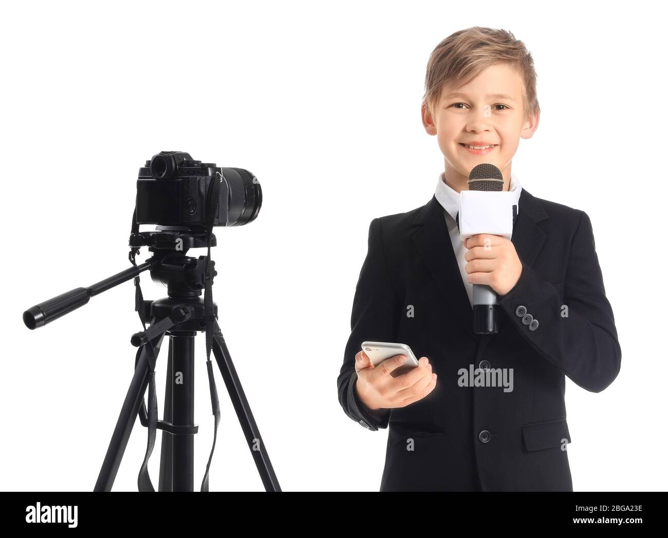 Little journalist with microphone, mobile phone and camera on white ...