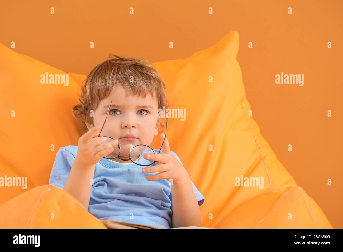 Cute little boy with eyeglasses on color background Stock Photo - Alamy
