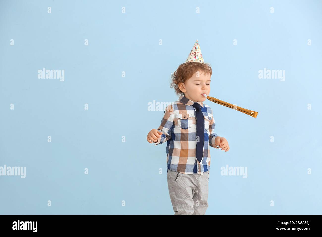 Cute little boy with party decor on color background Stock Photo - Alamy