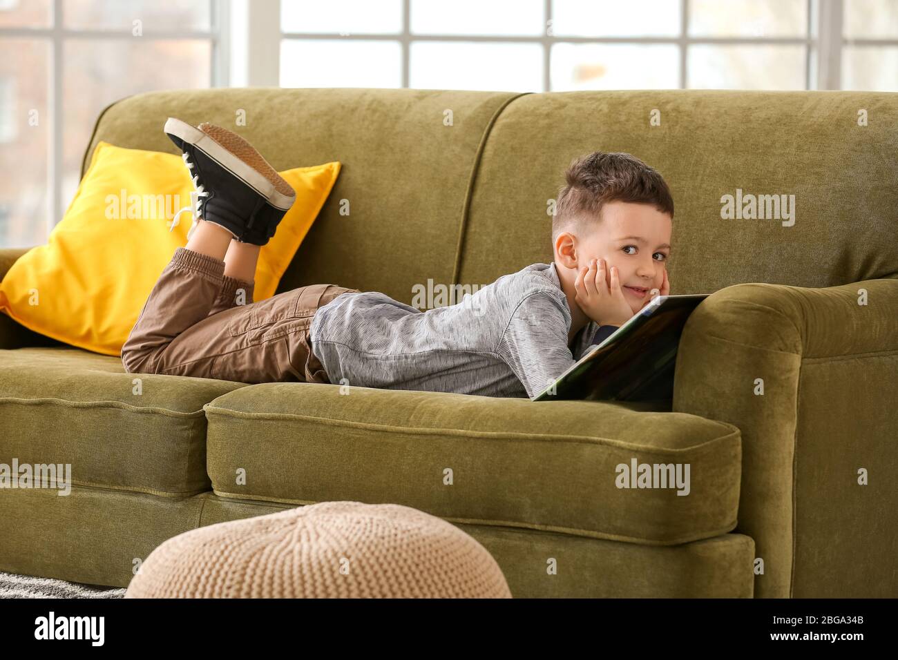 Cute little boy reading book at home Stock Photo - Alamy