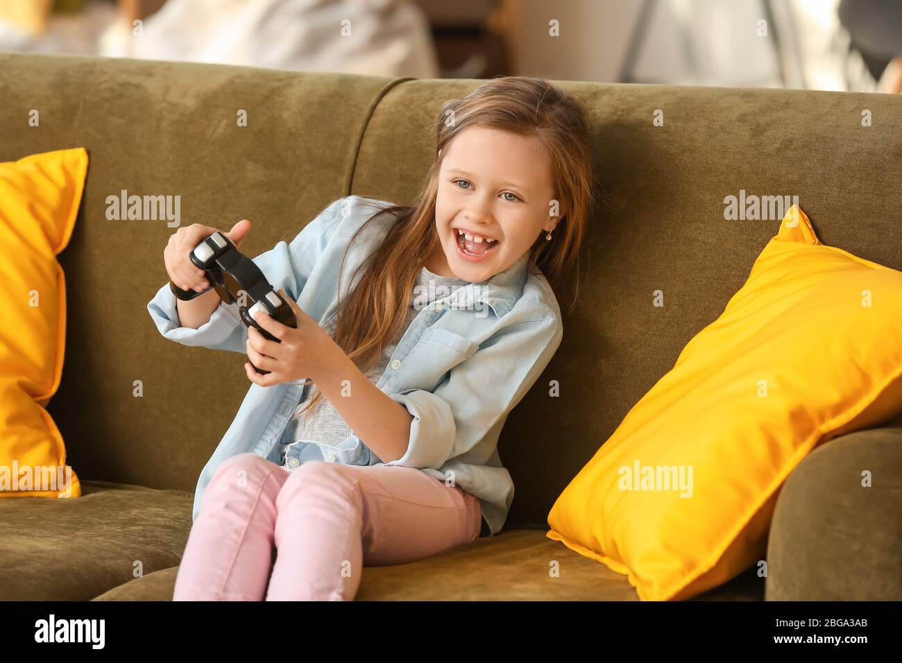 Happy little girl playing video games at home Stock Photo - Alamy