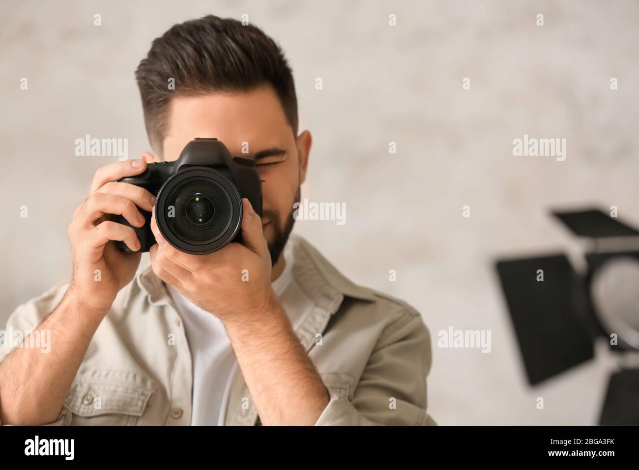 Male photographer with professional camera in studio Stock Photo - Alamy