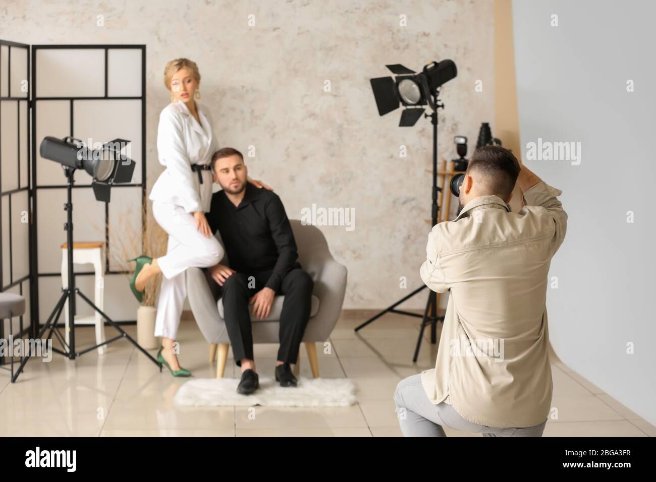 Photographer working with models in studio Stock Photo - Alamy