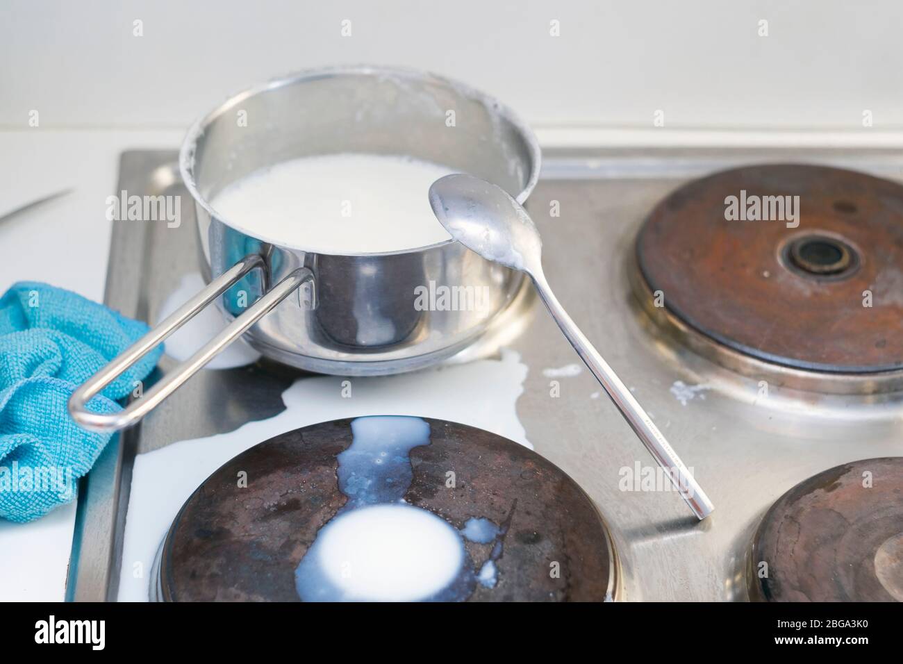 Spilled milk on a stove top while boiling in a casserole, indoor ...