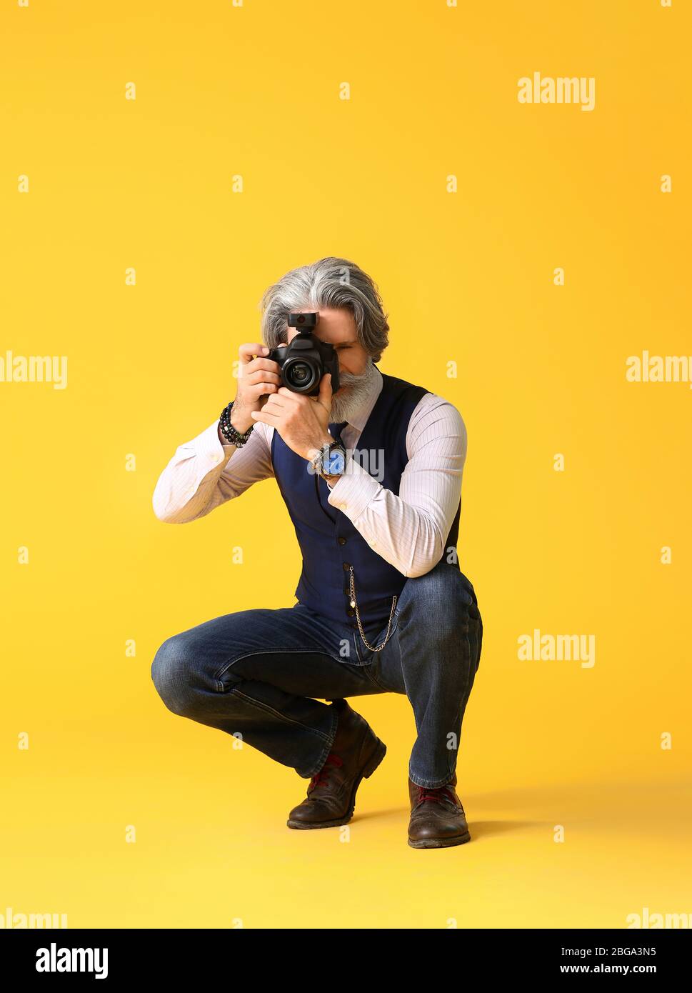 Handsome senior photographer on color background Stock Photo - Alamy