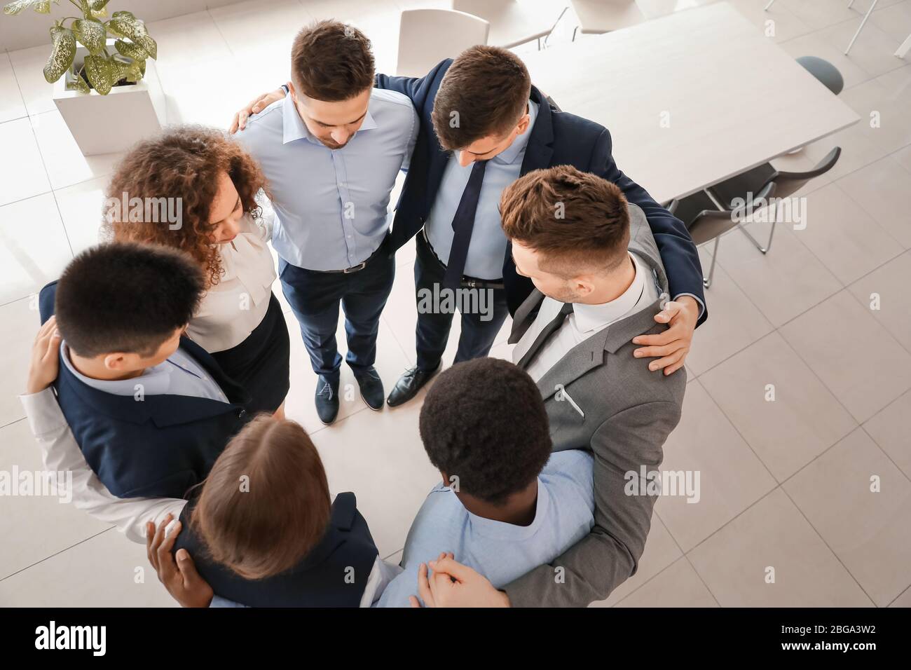 Group of business people hugging in office, top view. Unity concept ...