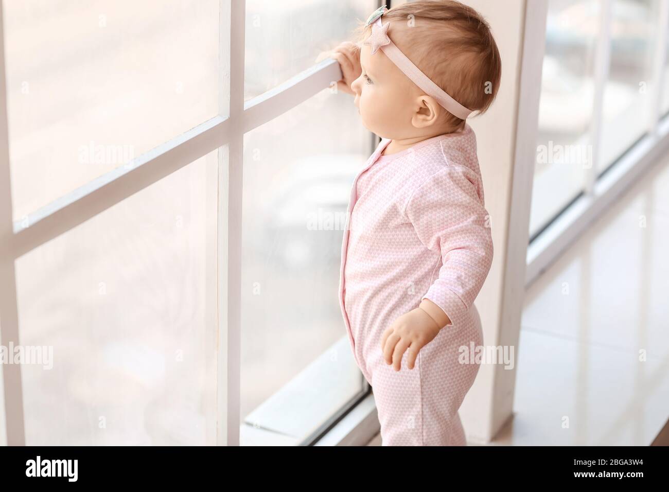 Little baby near window at home. Child in danger Stock Photo - Alamy